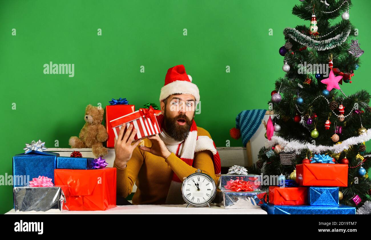 Santa holds gift box. Santa Claus holds presents near decorated tree on ...