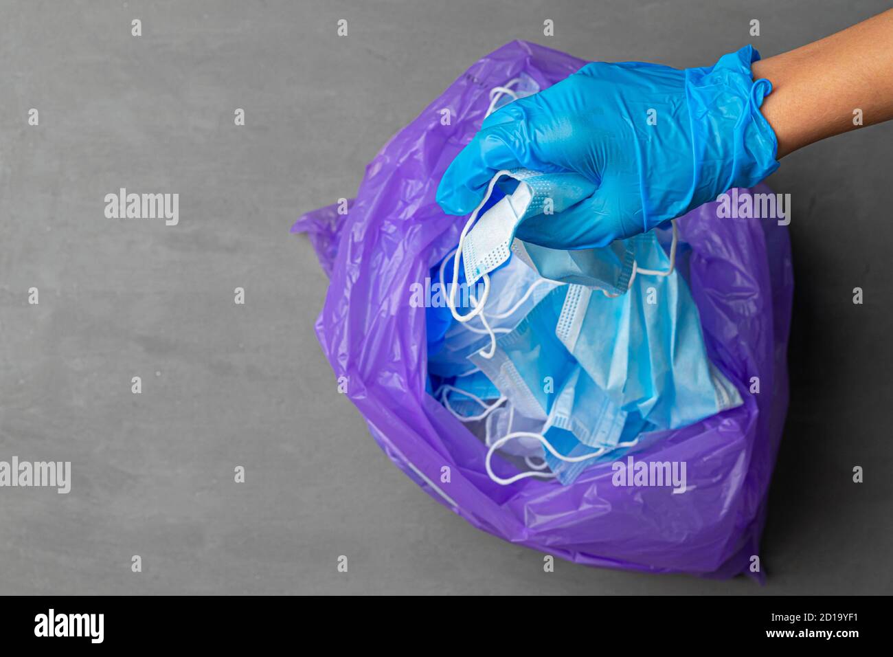 Hand putting used dirty surgical mask to a garbage bin Stock Photo - Alamy