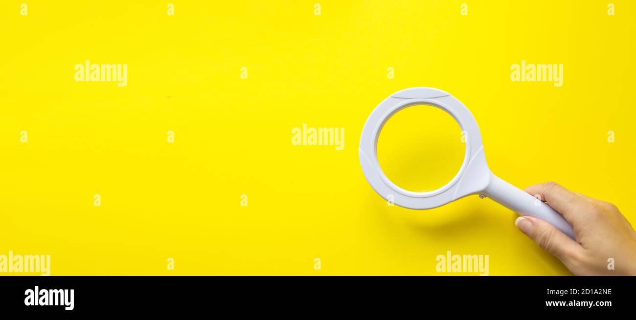Hand holding magnifying glass on yellow. Business analytics and ...
