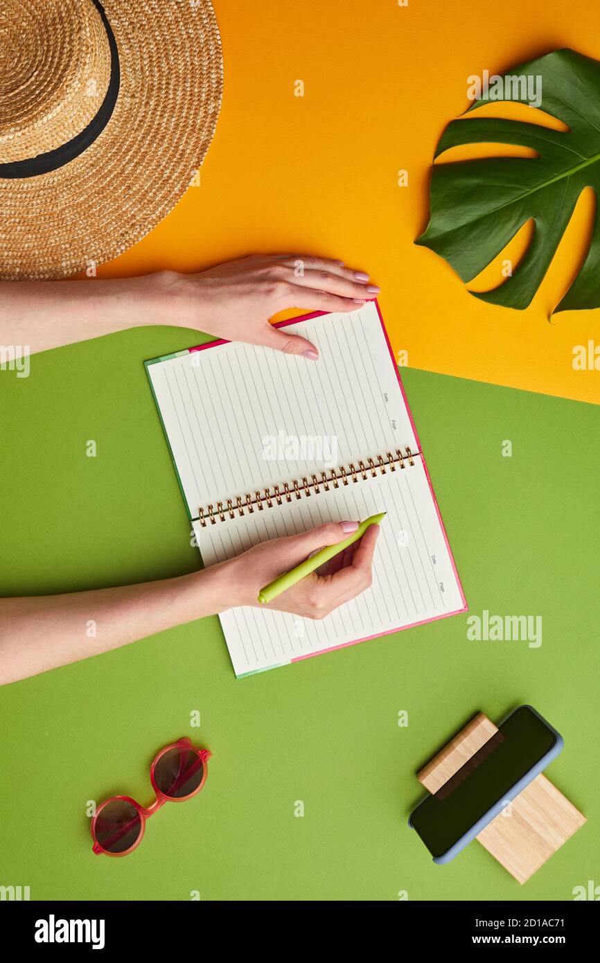 Bright color pop composition of female hands writing in planner over ...