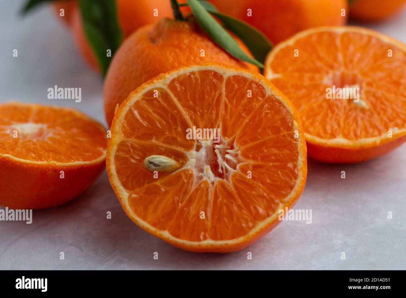 Whole and half mandarin pieces on a flat surface Stock Photo - Alamy