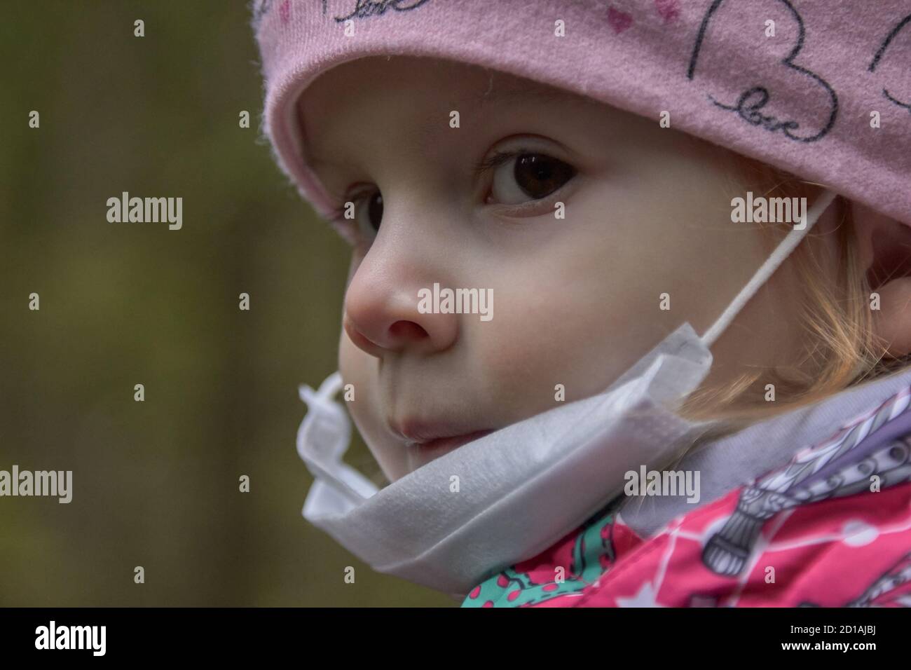 girl without sterile medical mask on his face looking at camera ...