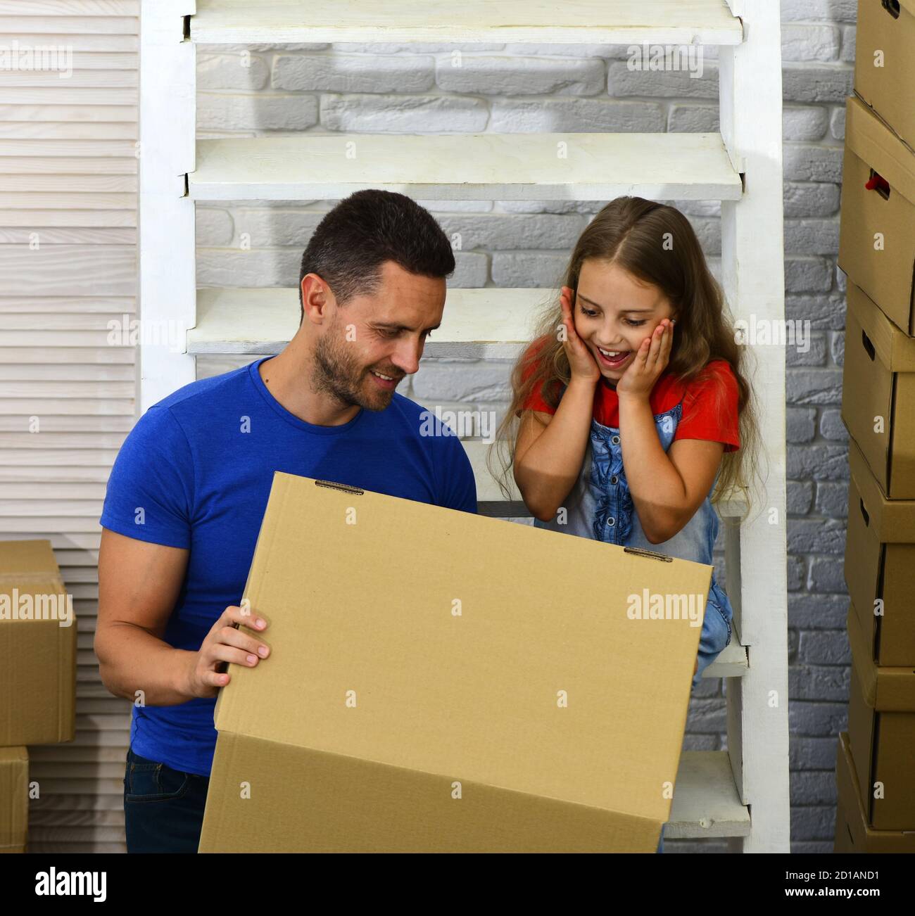 Father and child with excited faces look into box. Present or surprise ...