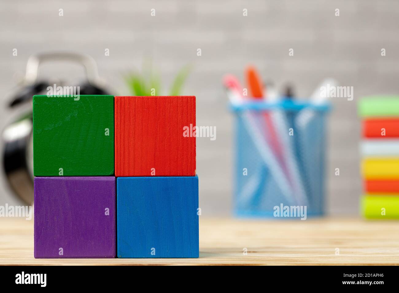 Wooden blocks and alarm clock on wooden desk Stock Photo - Alamy