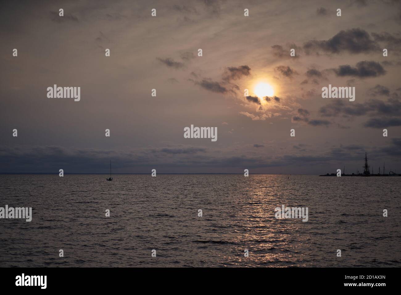 sunset on the beach with orange sun and glare on the water Stock Photo ...