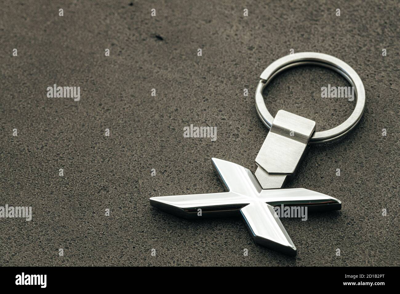 Metal letter X car key on dark concrete background Stock Photo - Alamy