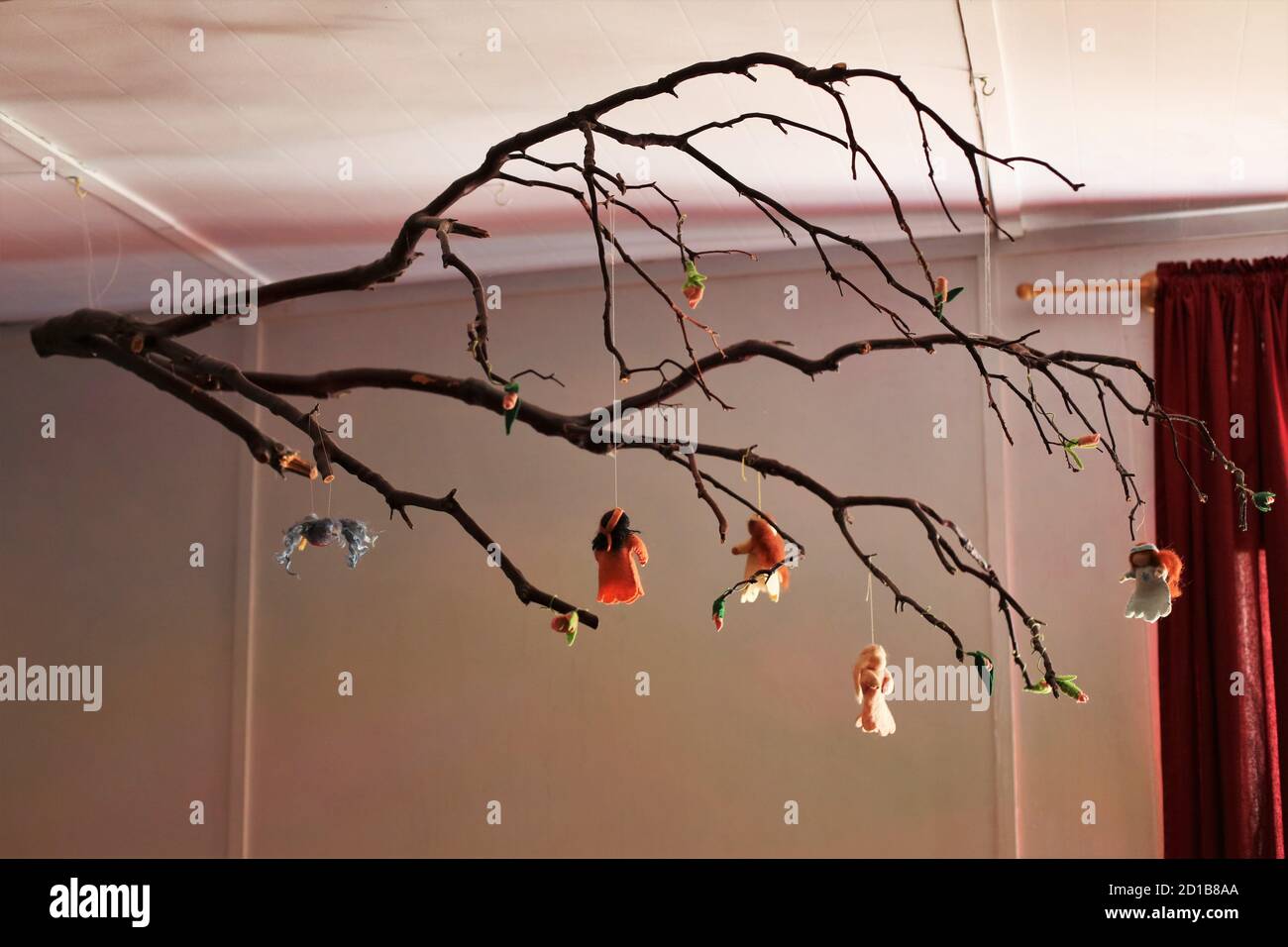 A child's mobile made from a branch and handmade dolls and other ...