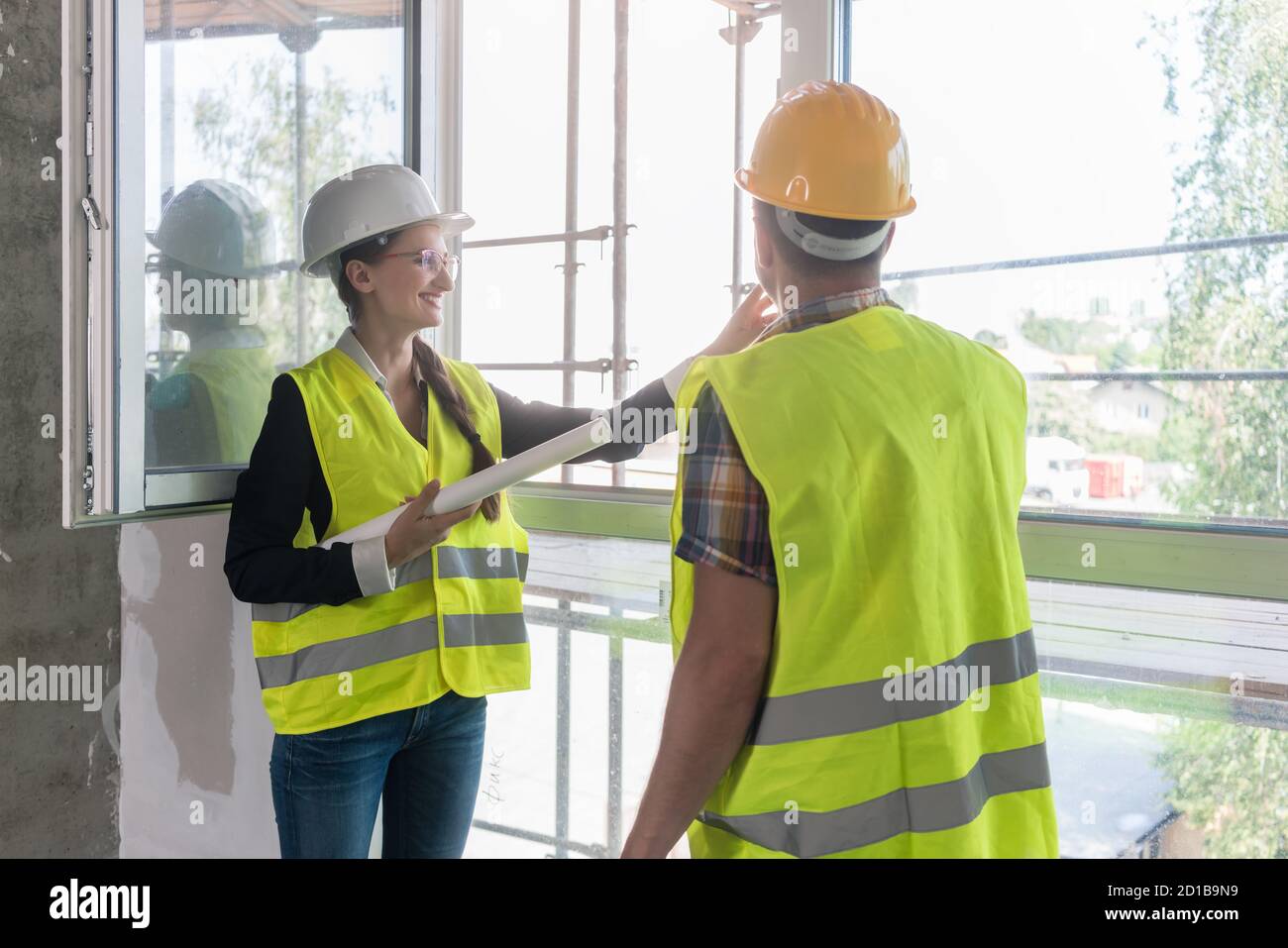 Construction workers inspecting windows on site Stock Photo - Alamy