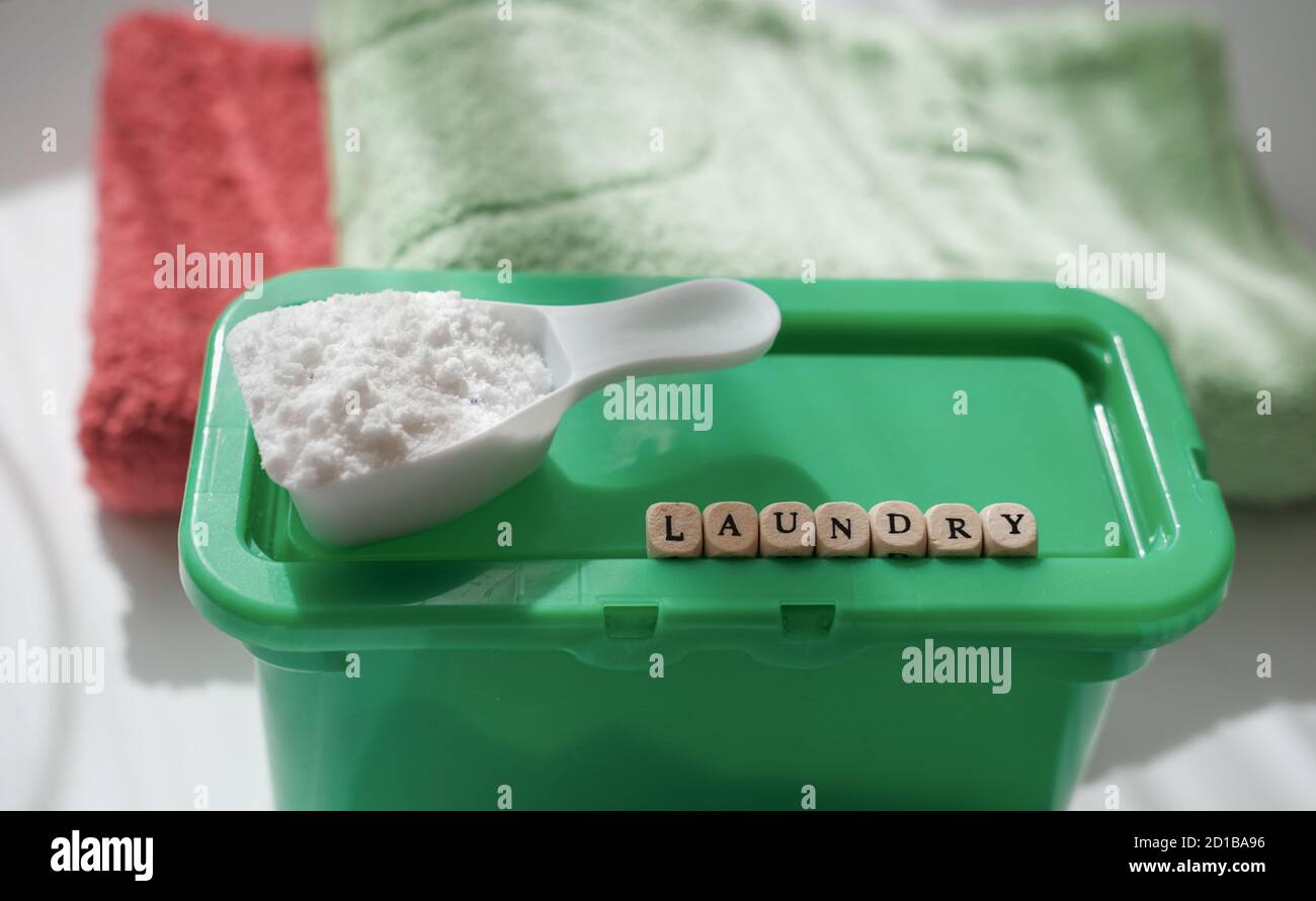 laundry word on dice. washing powder or detergent in a scoop. towels ...