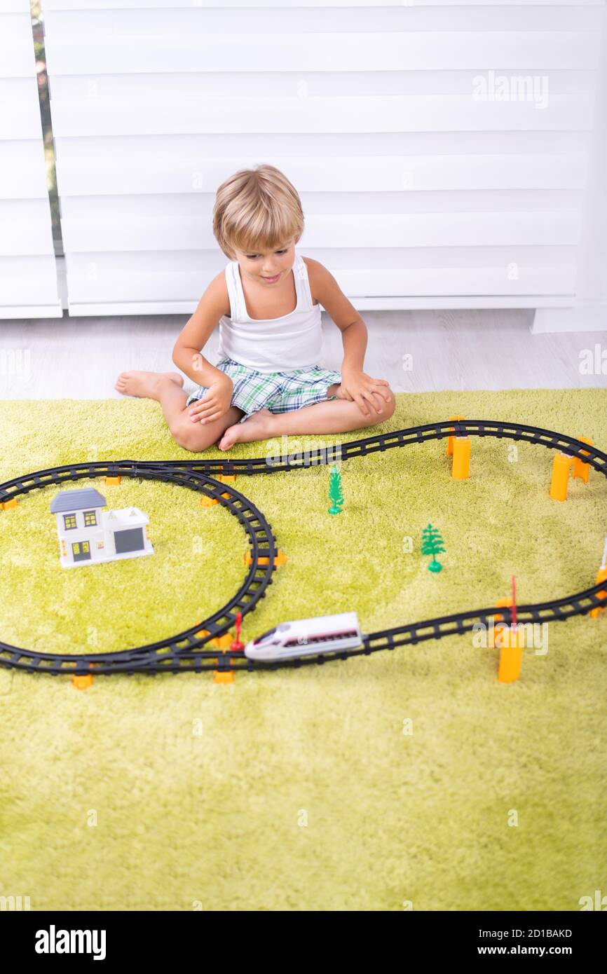 Little boy play with plastic railway. Child with toy train. Educational ...