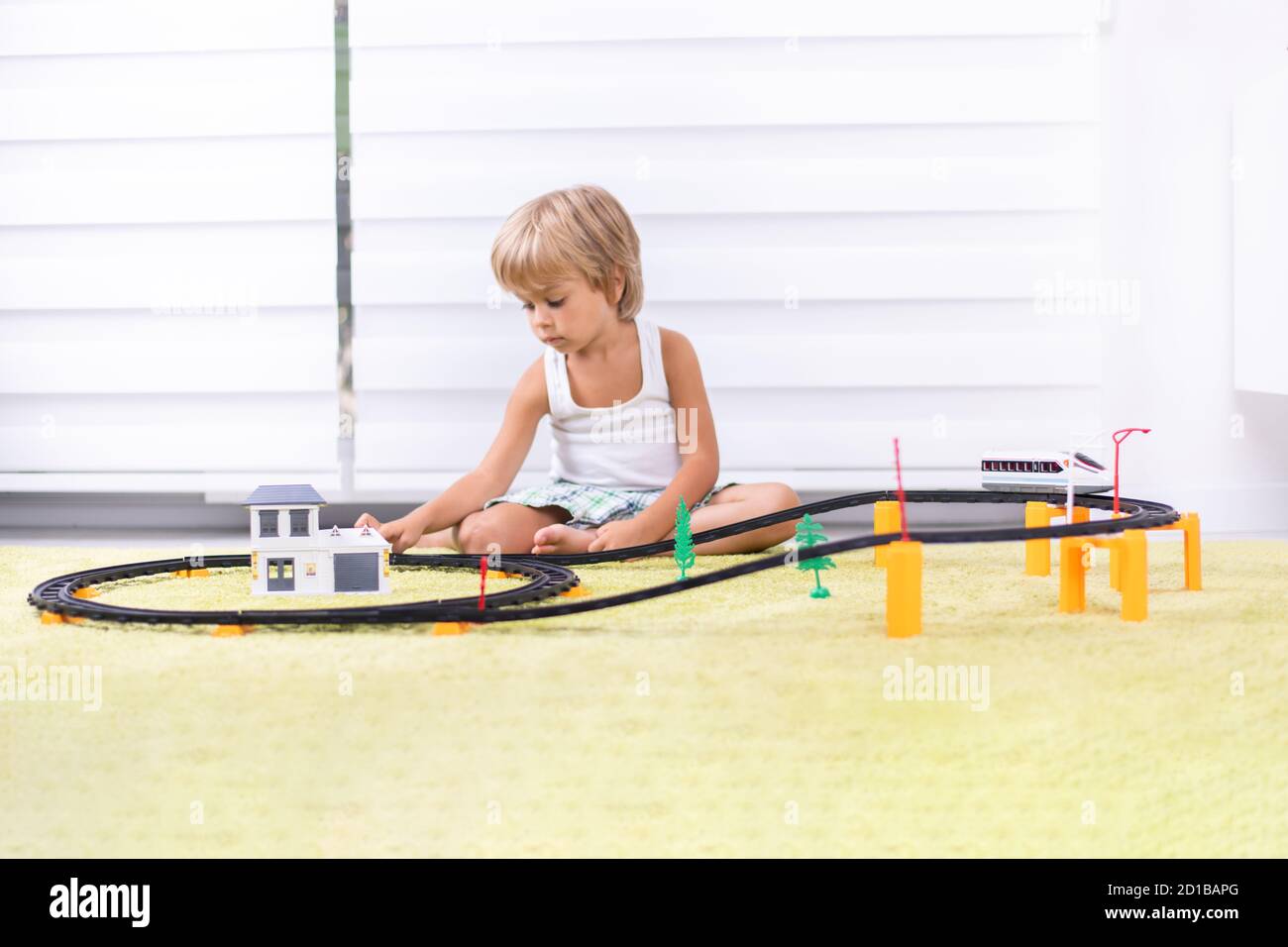 Little boy play with plastic railway. Child with toy train. Educational ...