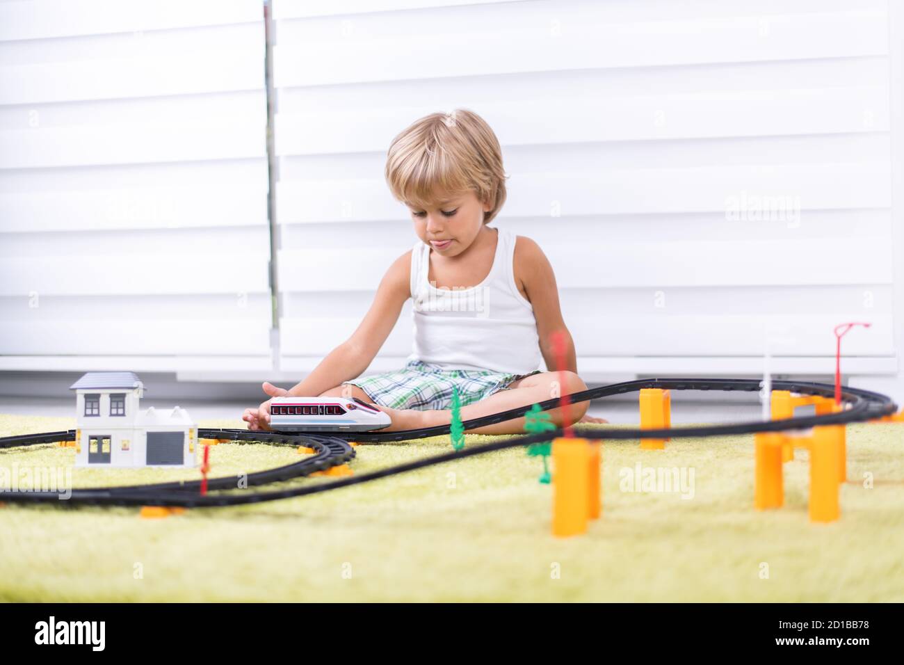 Little boy play with plastic railway. Child with toy train. Educational ...