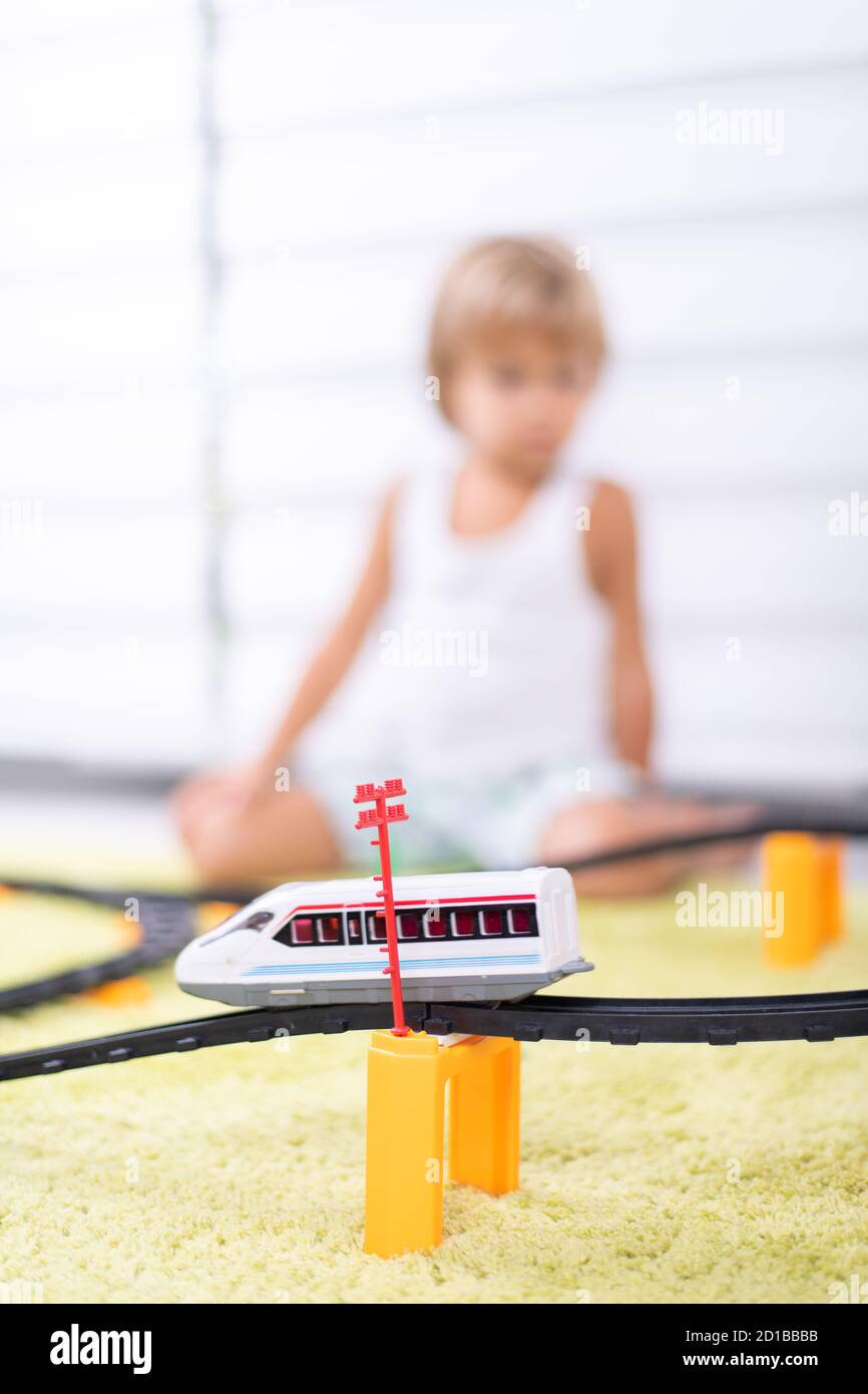Little boy play with plastic railway. Child with toy train. Educational ...