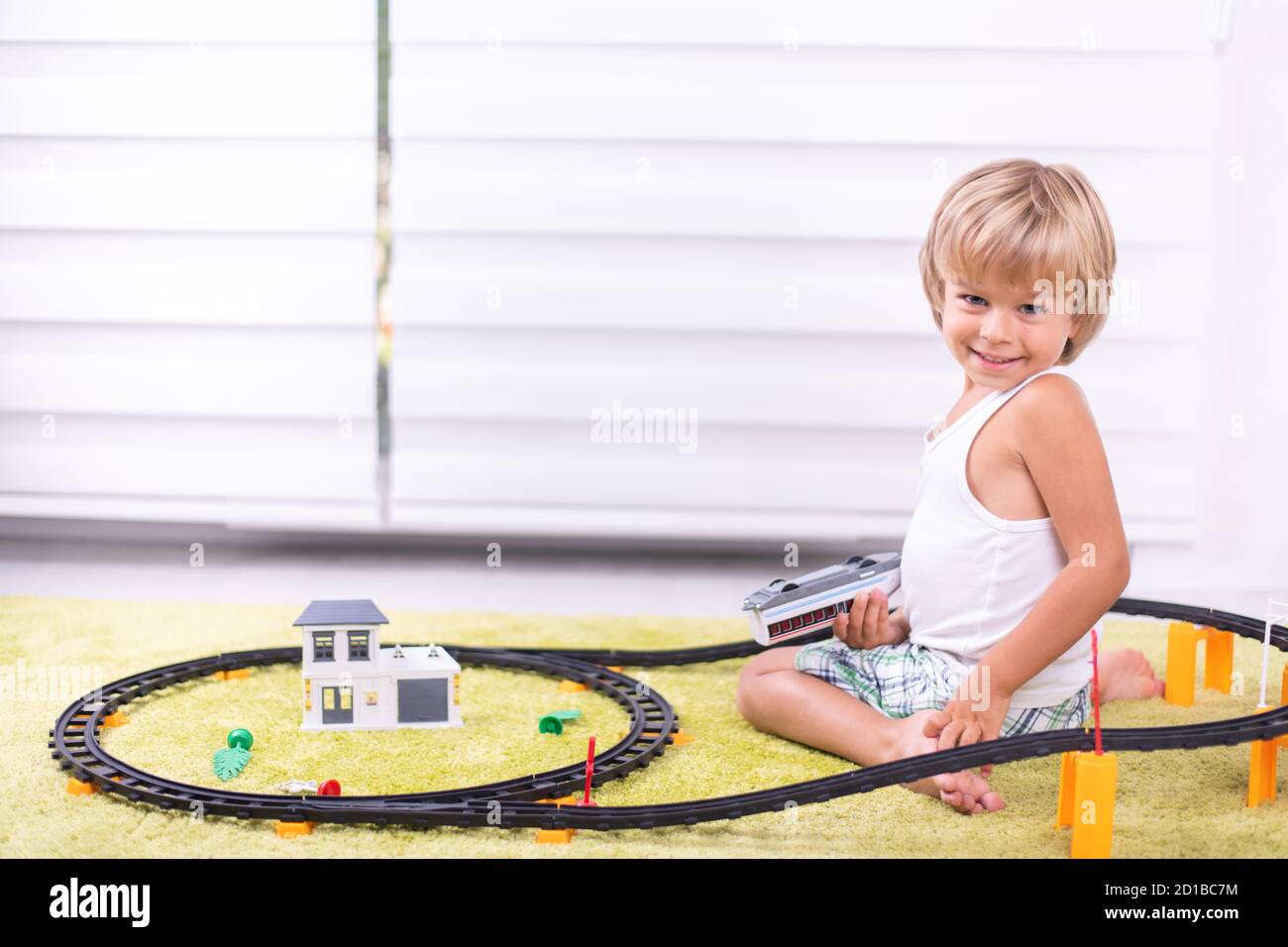 Little boy play with plastic railway. Child with toy train. Educational ...