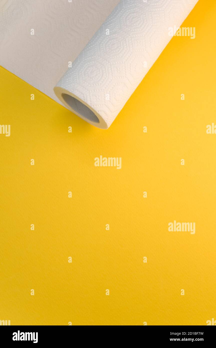 Kitchen paper roll on a yellow background Stock Photo - Alamy