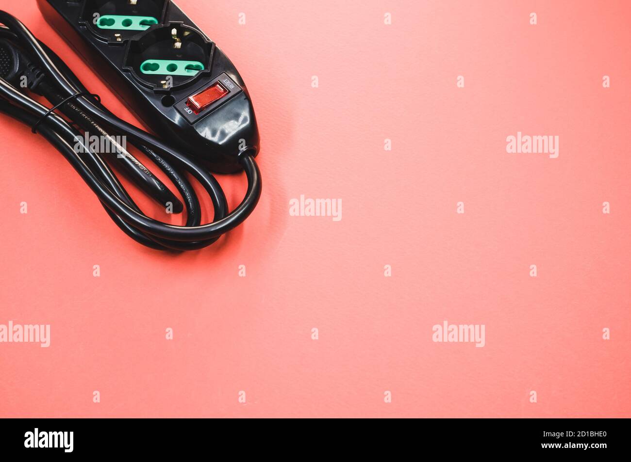 Black surge protector on a light red background Stock Photo - Alamy
