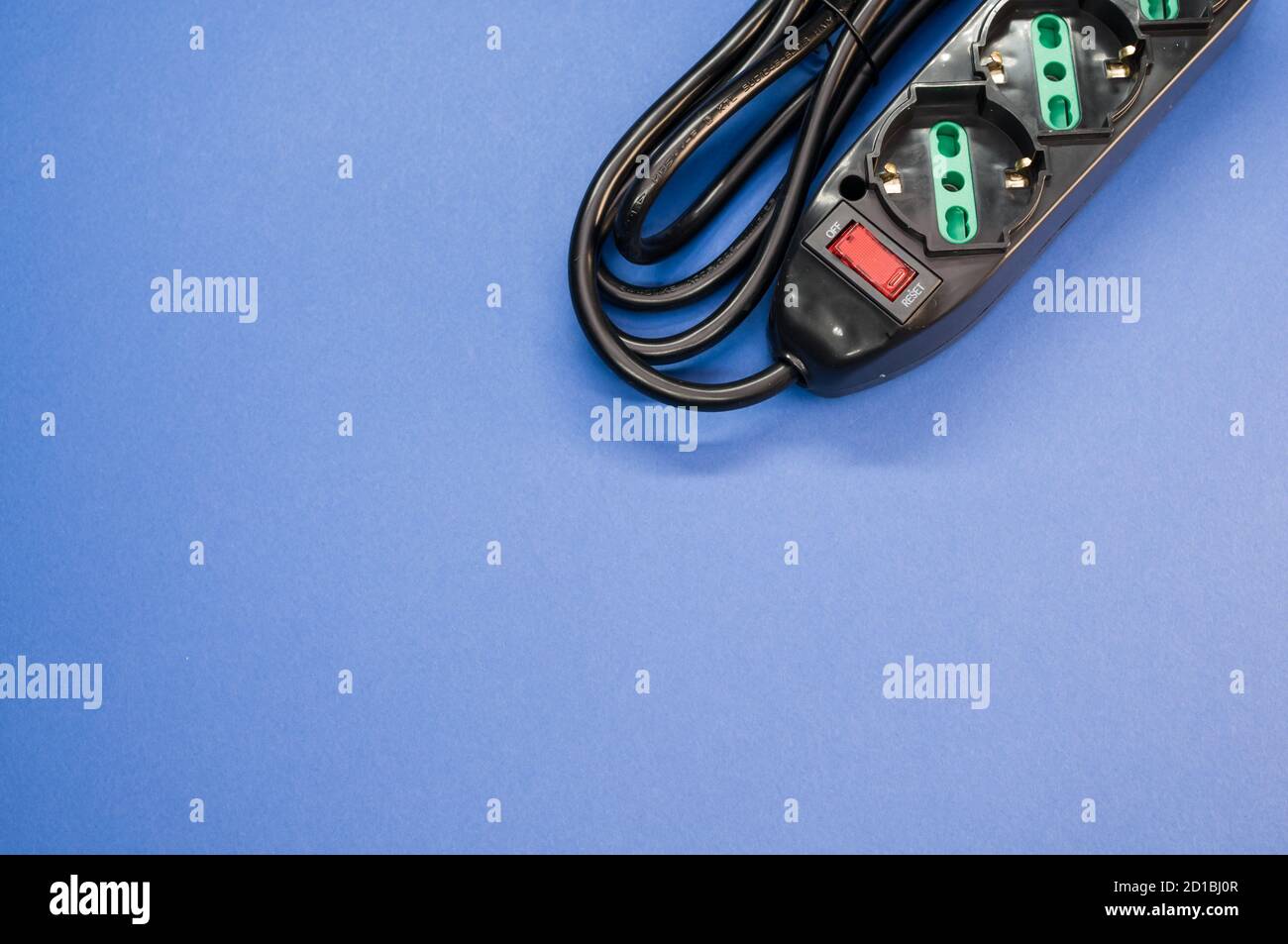 Black surge protector on a blue background Stock Photo - Alamy
