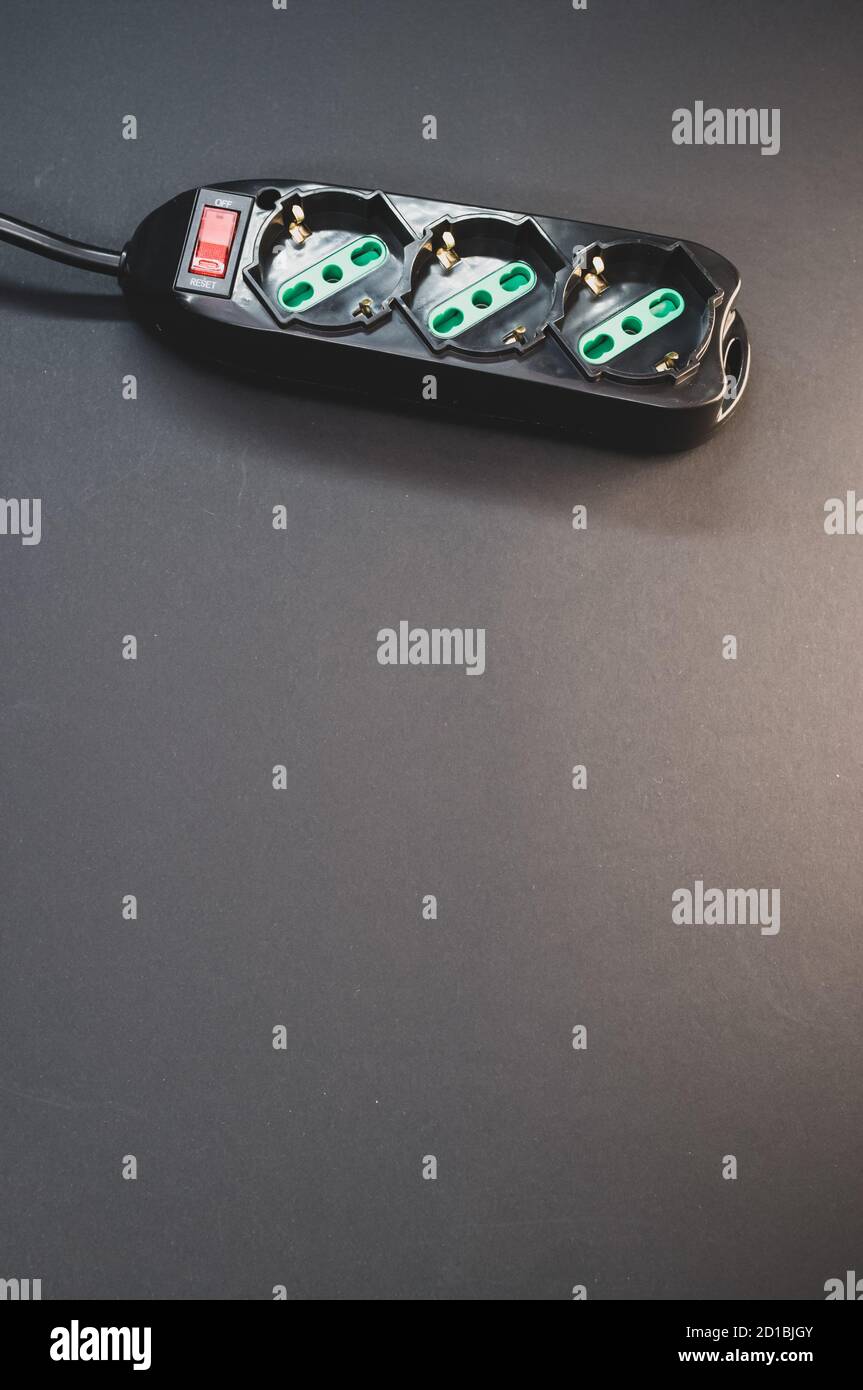 Black surge protector on a black background Stock Photo - Alamy