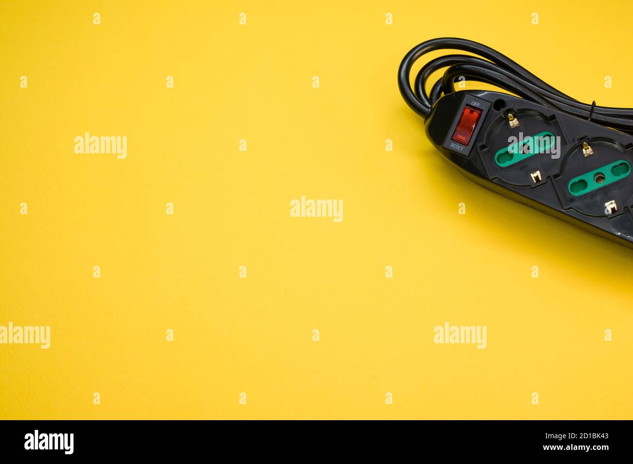 Black surge protector on a yellow background Stock Photo - Alamy