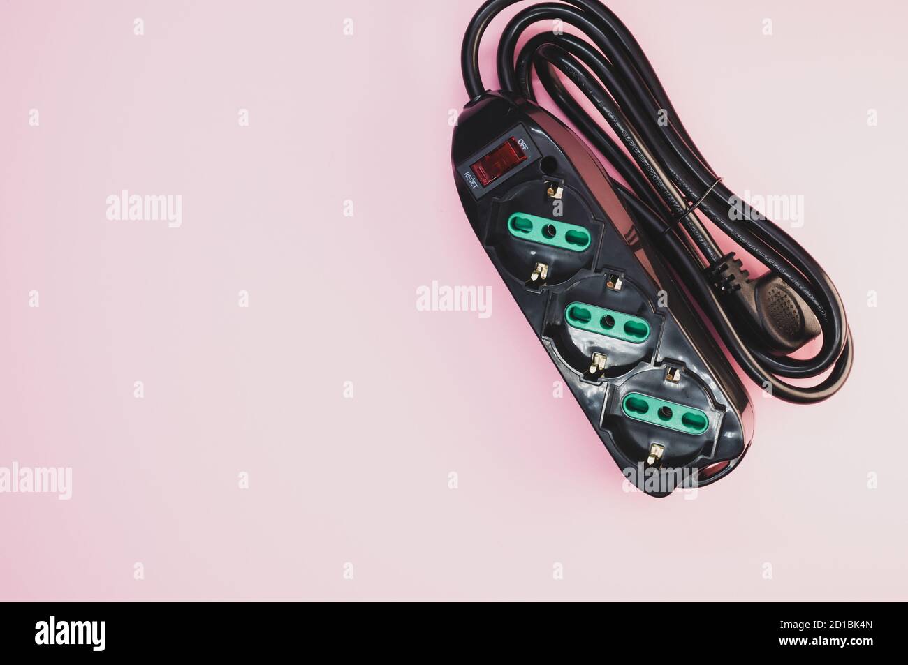 Black surge protector on a light pink background Stock Photo - Alamy