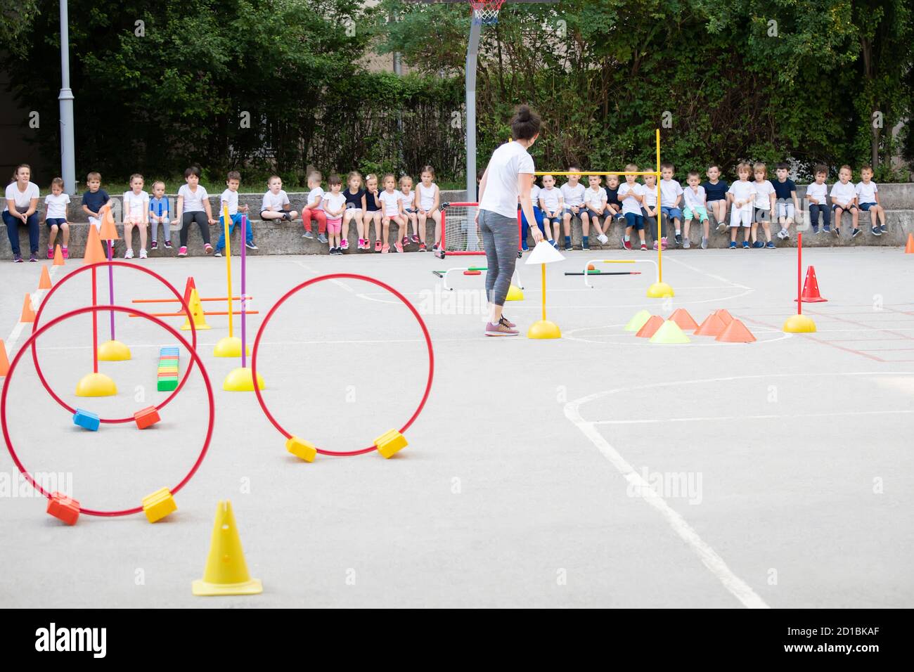 Group of children sitting on the stairs and watching trainer practical ...