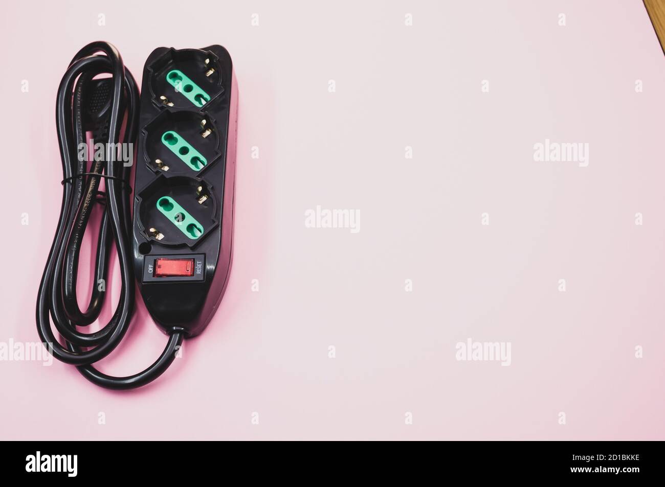 Black surge protector on a light pink background Stock Photo - Alamy