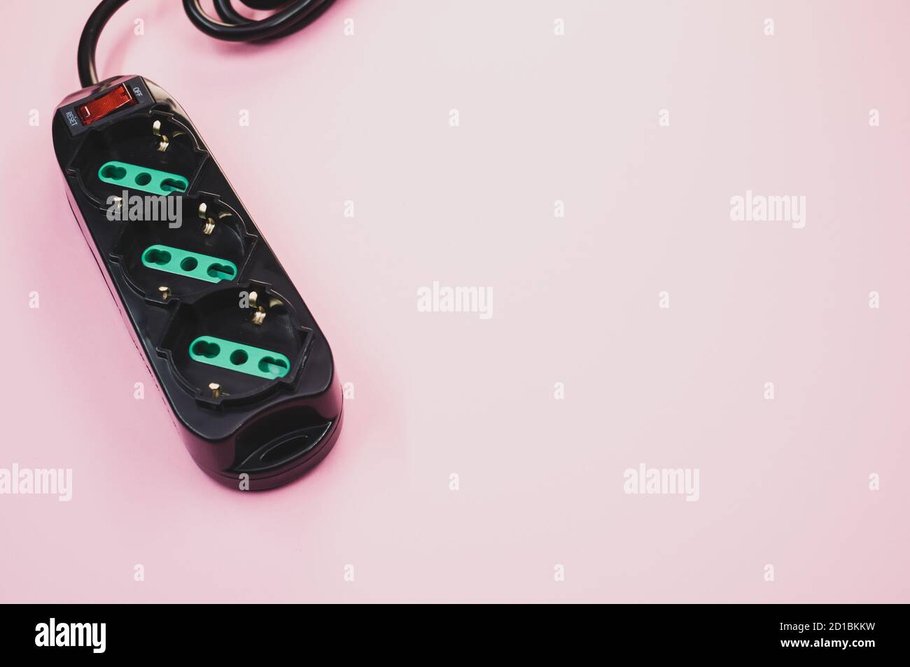 Black surge protector on a light pink background Stock Photo - Alamy