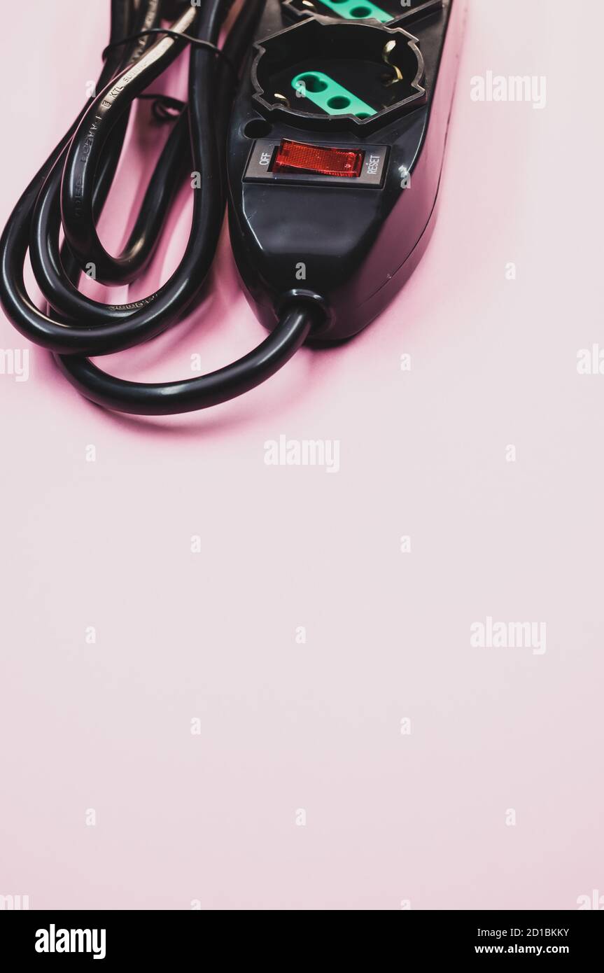 Black surge protector on a light pink background Stock Photo - Alamy