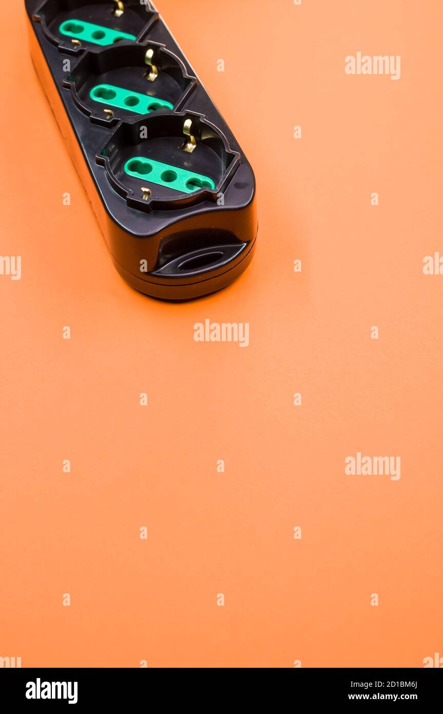 Black surge protector on an orange background Stock Photo - Alamy