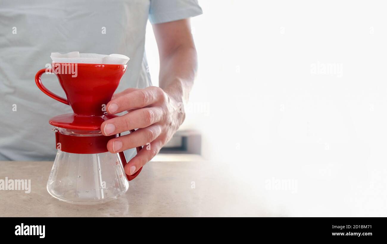 Set for making V60 on the table. Men's hand holds glass server ...