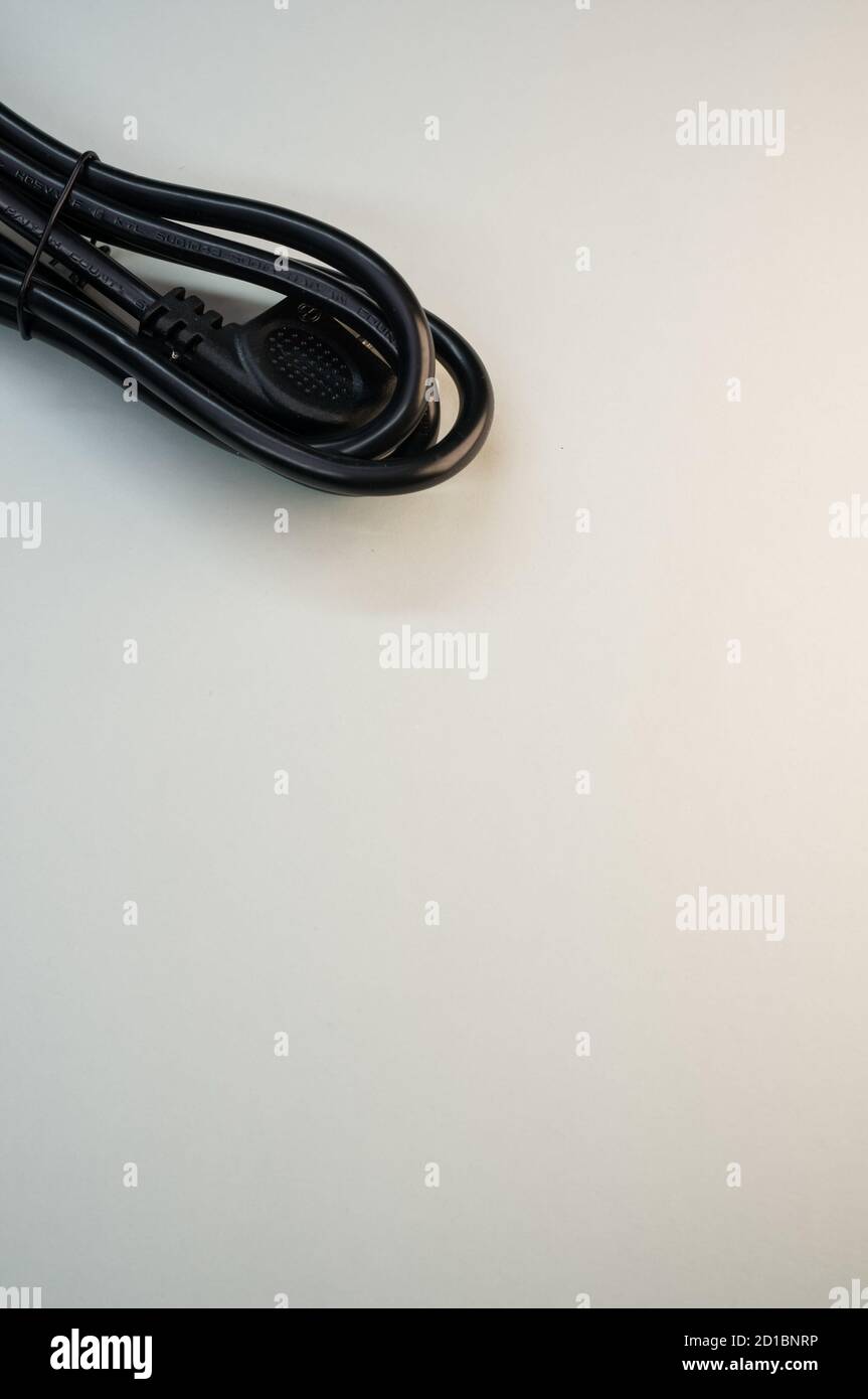 Black power cable on a gray background Stock Photo - Alamy