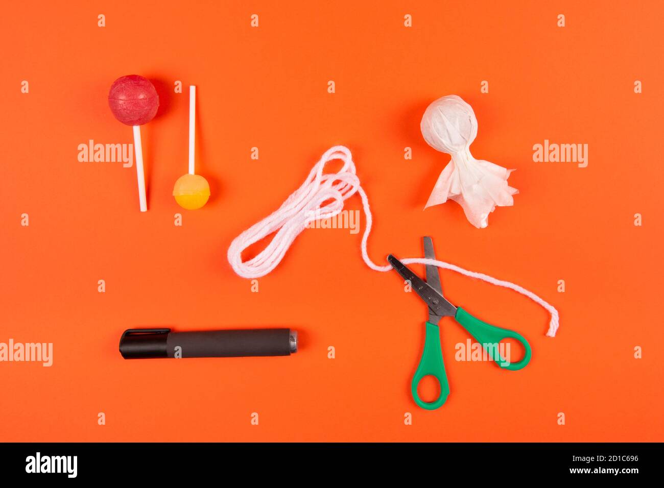 Halloween DIY concept. Make a cute ghost out of candy on a stick. Step ...