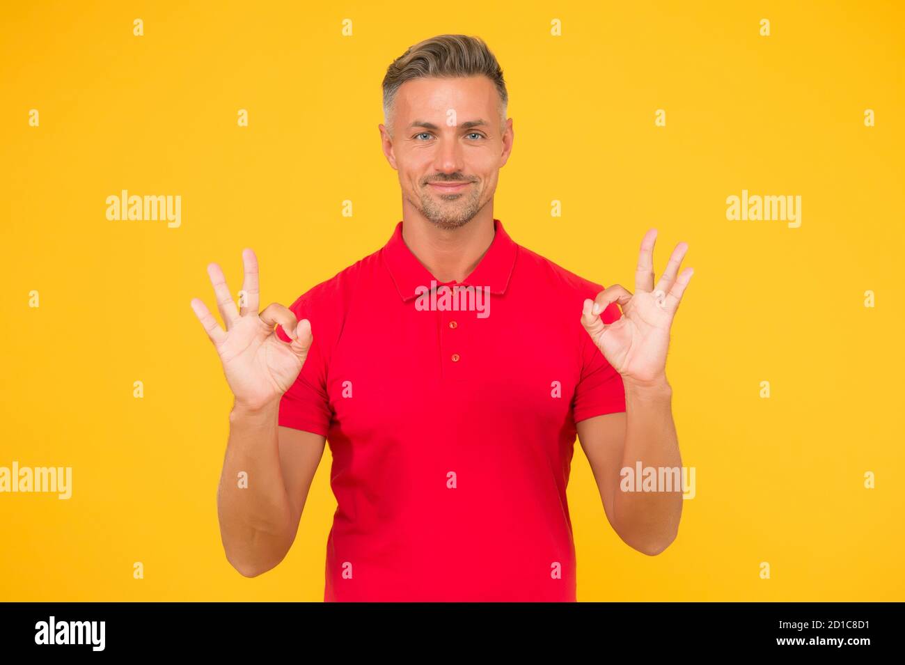 Satisfactory result. Happy man show double OK signs yellow background ...