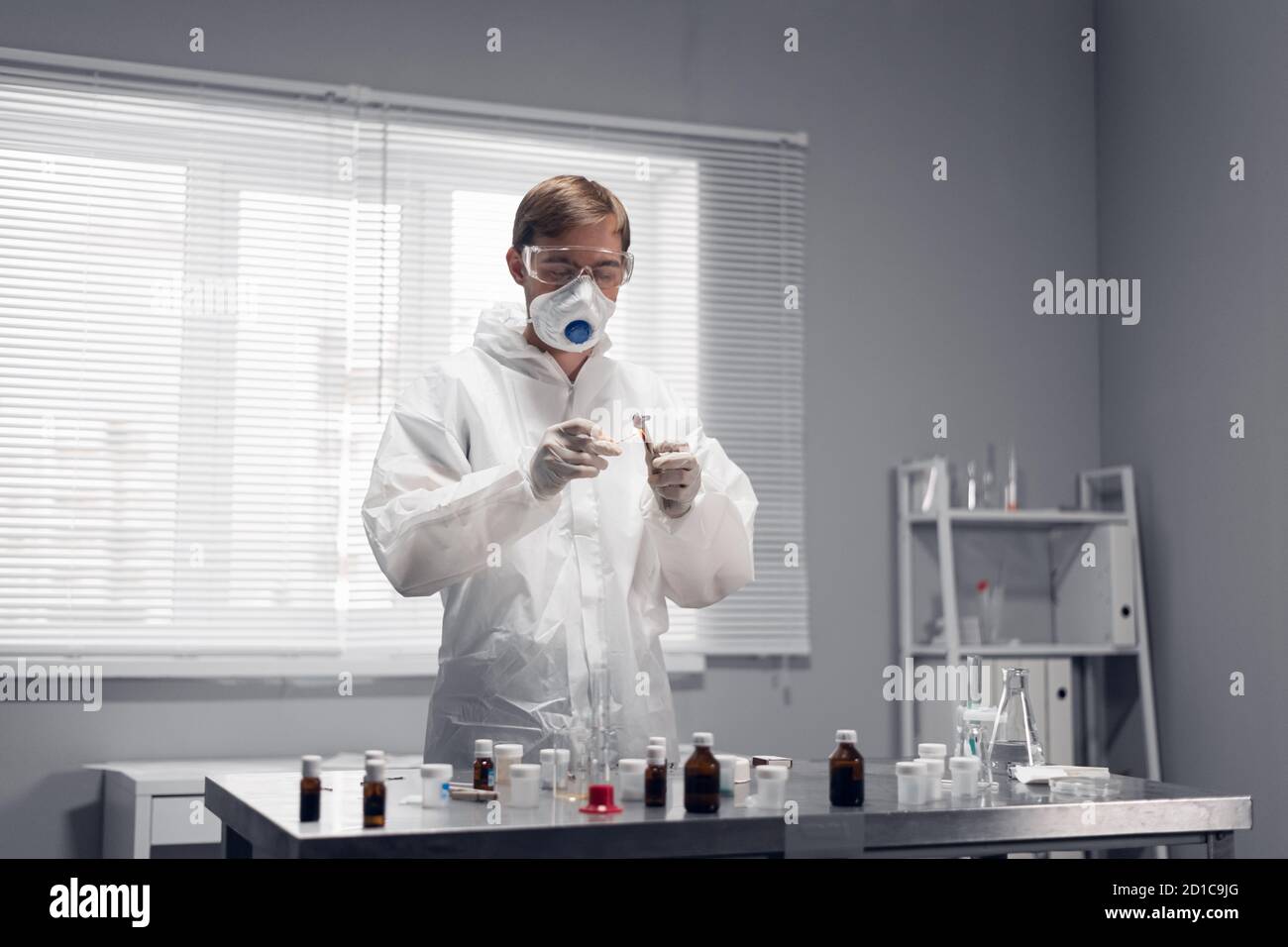 A scientist with gloved hands burning a piece of paper in his lab Stock ...