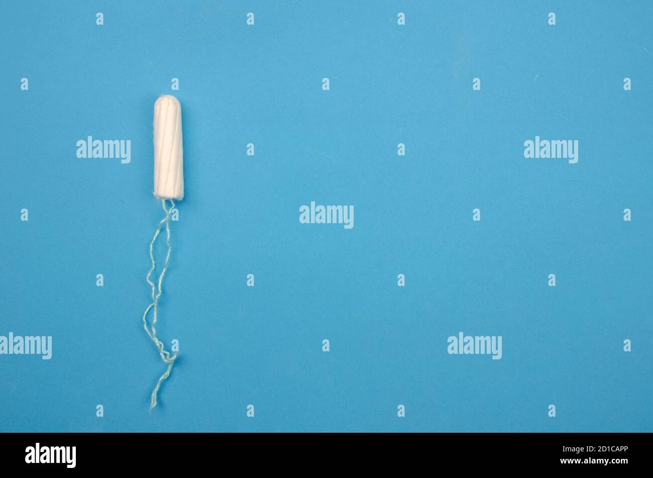 Medical female tampon on a blue background with copy space. Hygienic ...
