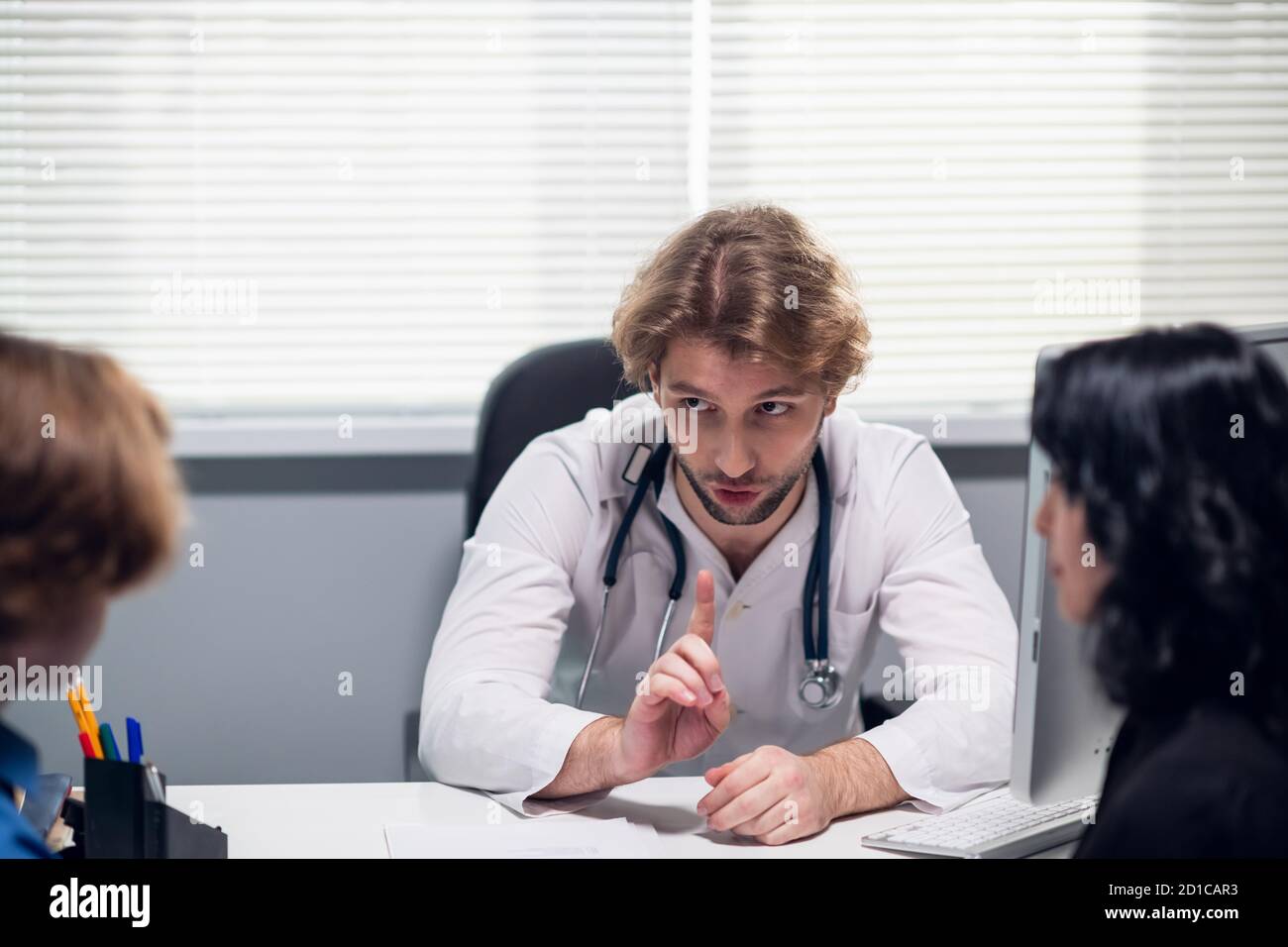 A family doctor conducting a medical checkup, asking questions, making ...