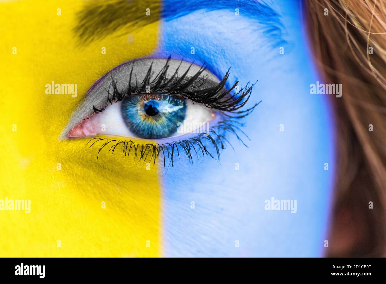 Closeup of a woman's beautiful blue eyes with yellow and blue tinted ...
