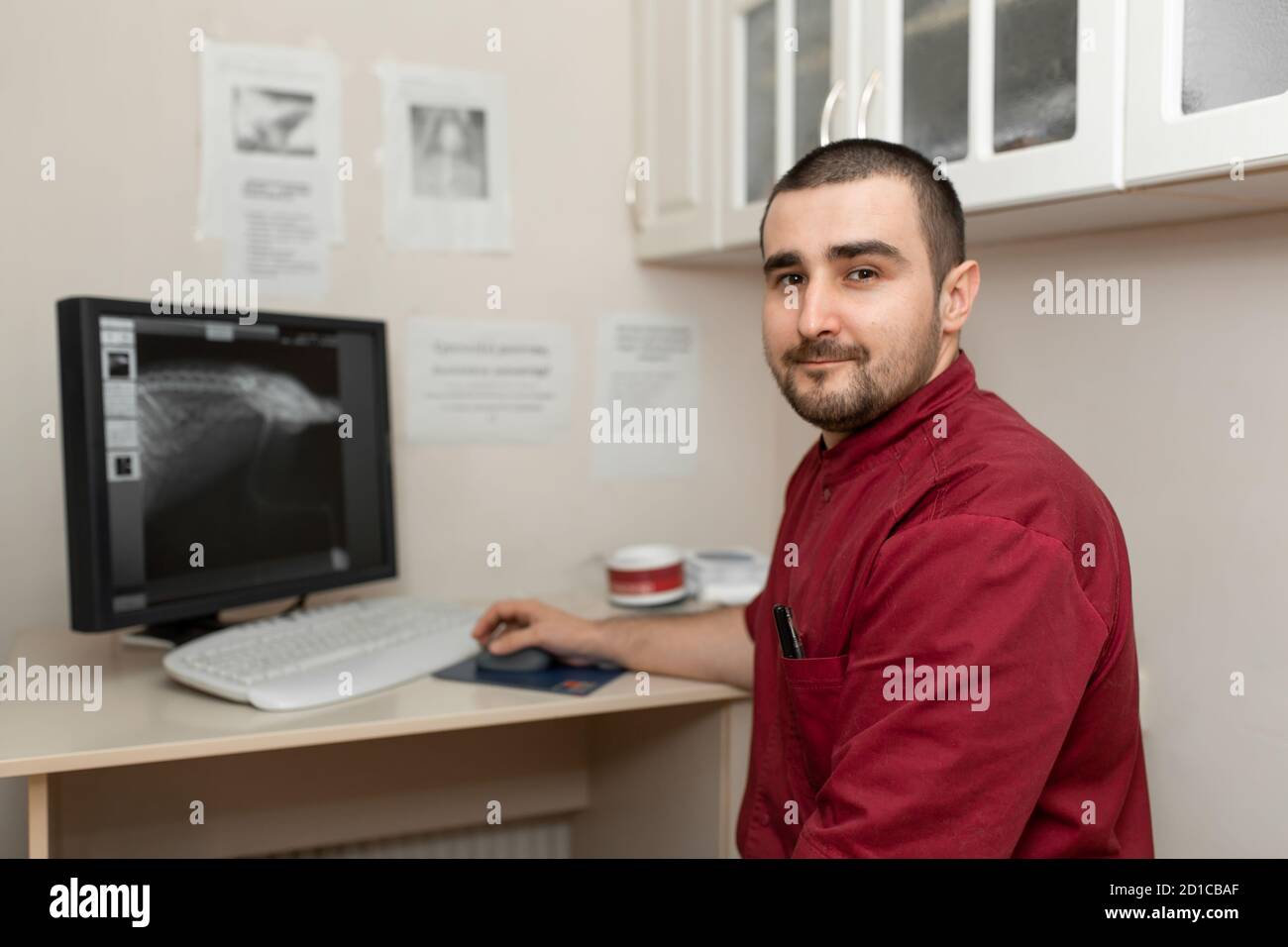A doctor radiologist at the workplace looks at images from an X-ray ...