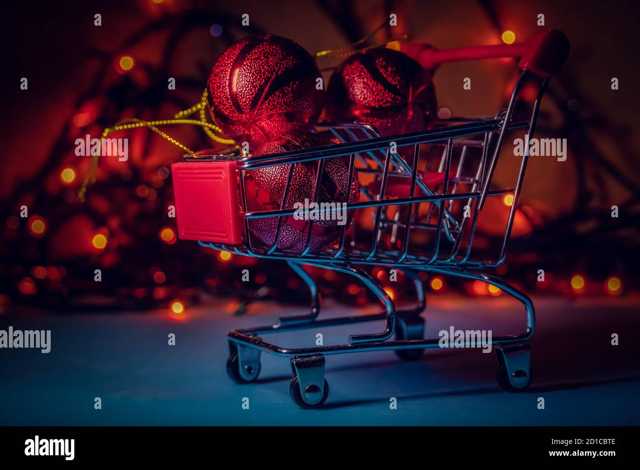 Shopping cart with red Christmas balls close-up on the background of ...