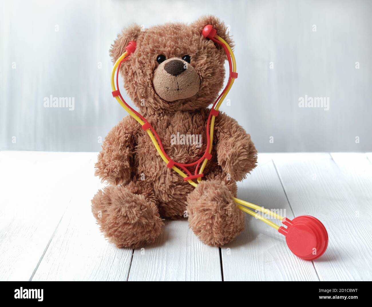 Toy stethoscope and teddy bear on wooden table. Doctor tool. People or ...