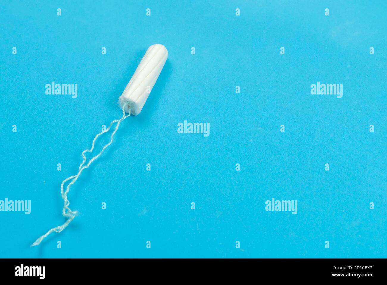 Medical female tampon on a blue background with copy space. Hygienic ...