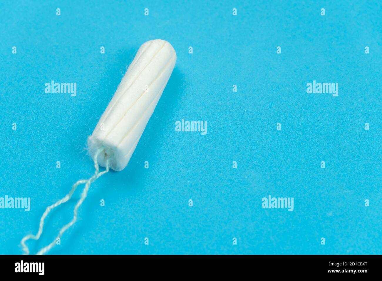 Medical female tampon on a blue background with copy space. Hygienic ...