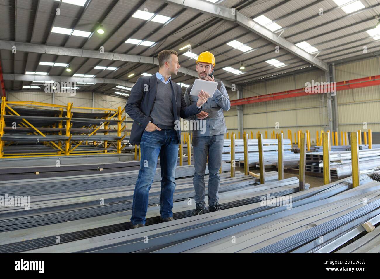 two workers in the interior of an industrial hall Stock Photo - Alamy