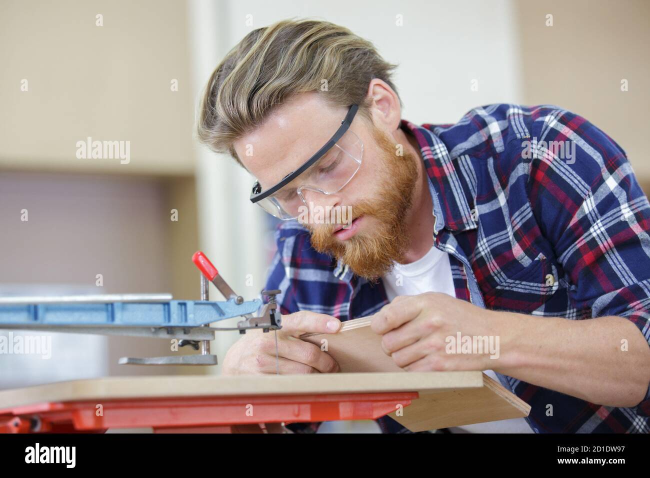 man using a machine to cut wood Stock Photo - Alamy