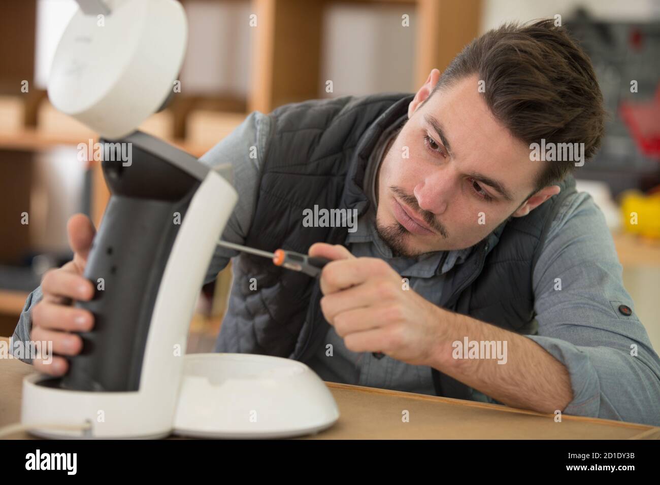 serious man repairing broken coffee machine Stock Photo - Alamy