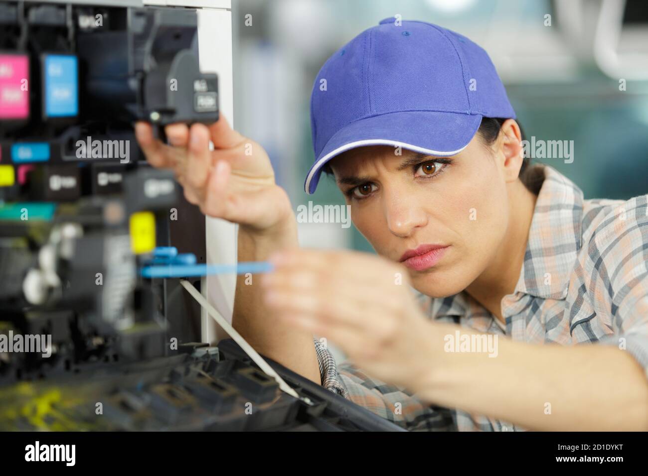 female technician putting set of ink into plotter Stock Photo - Alamy