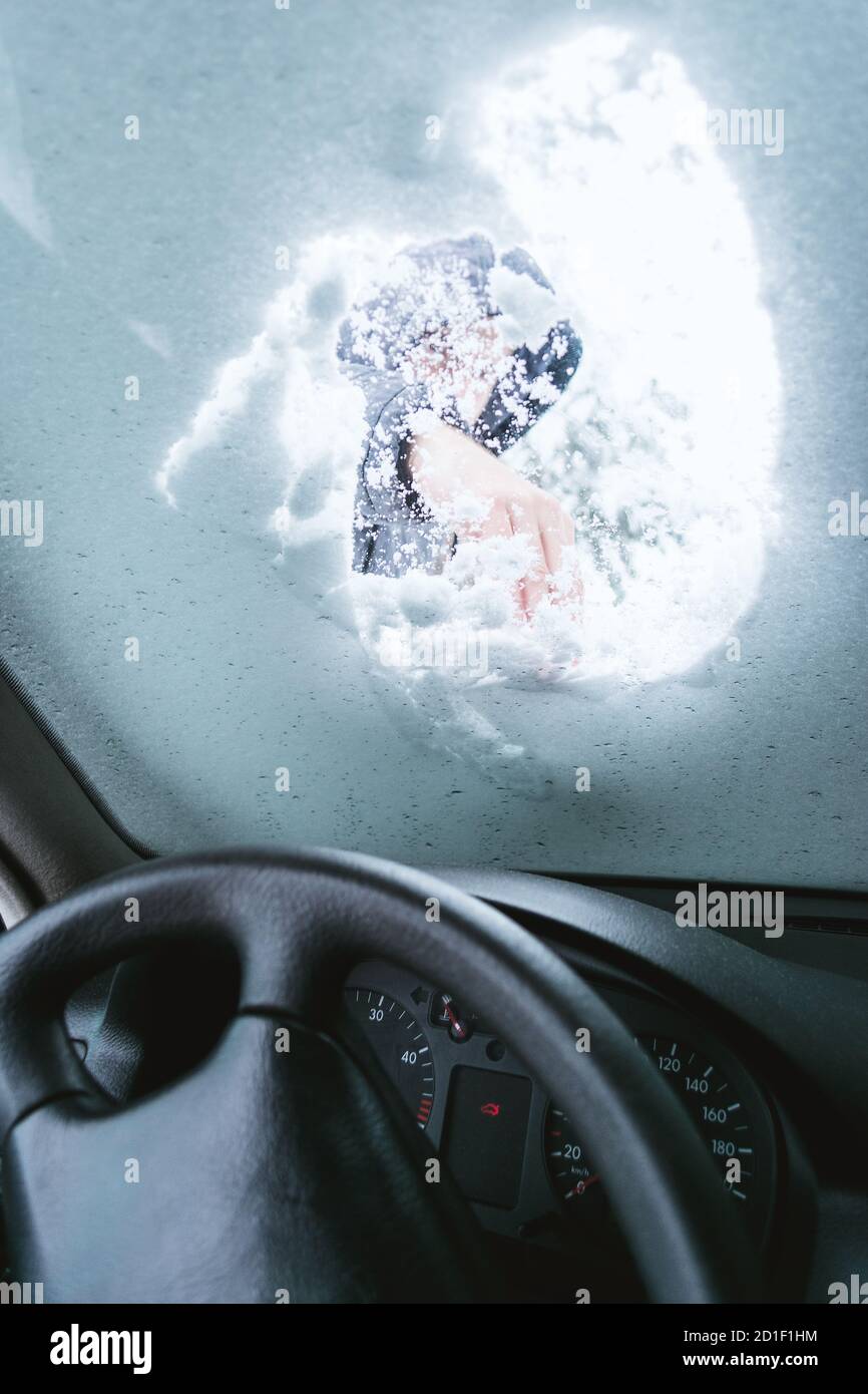 Man outdoor cleaning snow on his car windshield.View from inside of car ...