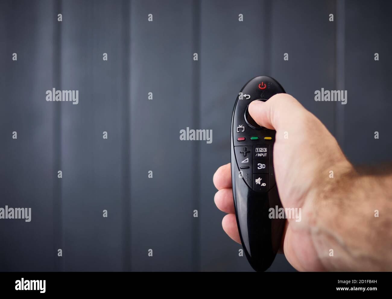 Modern remote control of a television held by a hand of a white or ...