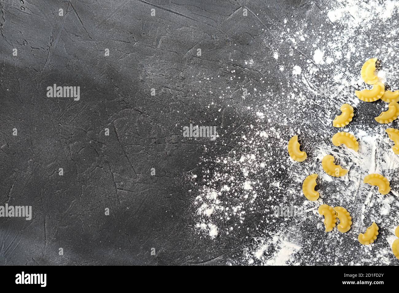 Yellow raw pasta on grey background with flour. Yellow italian pasta ...
