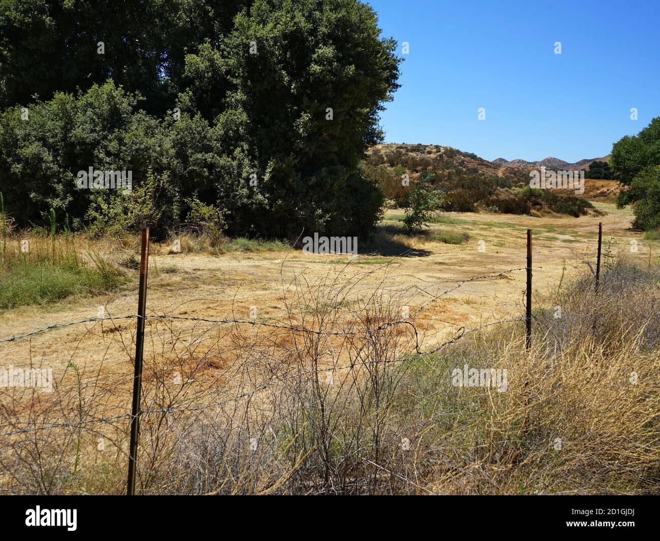 Abandoned dirt road behine a barbed wire fence Stock Photo - Alamy